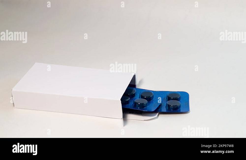 Close-up. Two blue pill blisters stick out of the box on a white ...