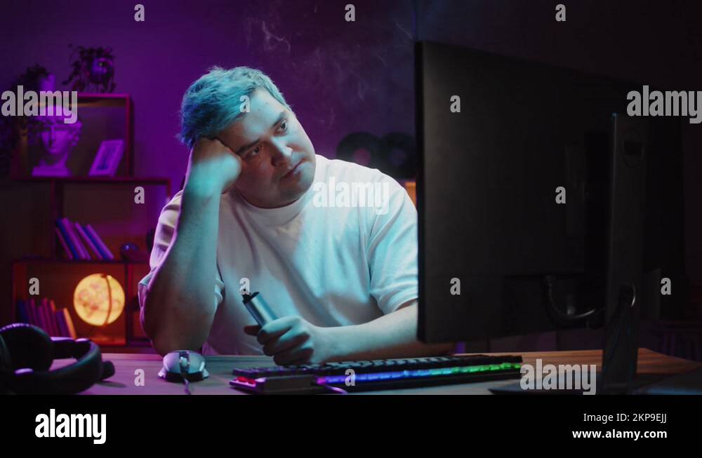 Sad gamer smoking close-up. Young man playing video games using ...