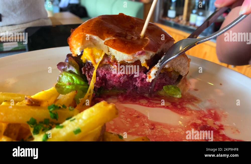 Eating an extra juicy cheeseburger with cheddar cheese, lettuce ...