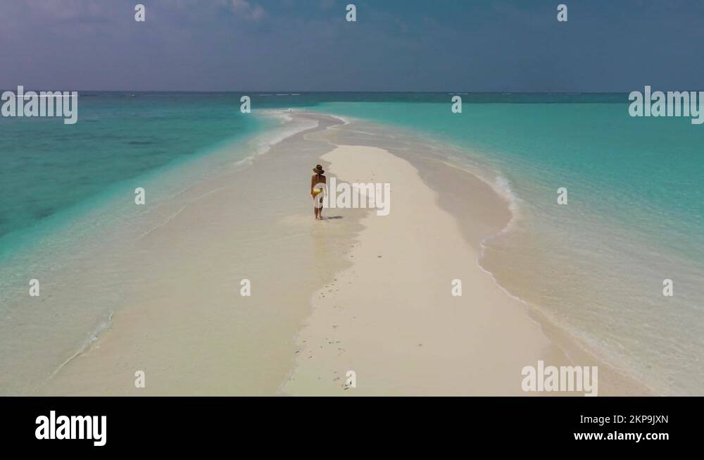 a sandy spit in the middle of the ocean washed from all sides by blue ...