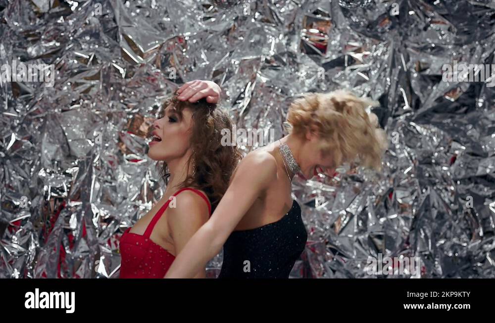 Two Girls Dancing On Silver Background Party They Touch Their Backs