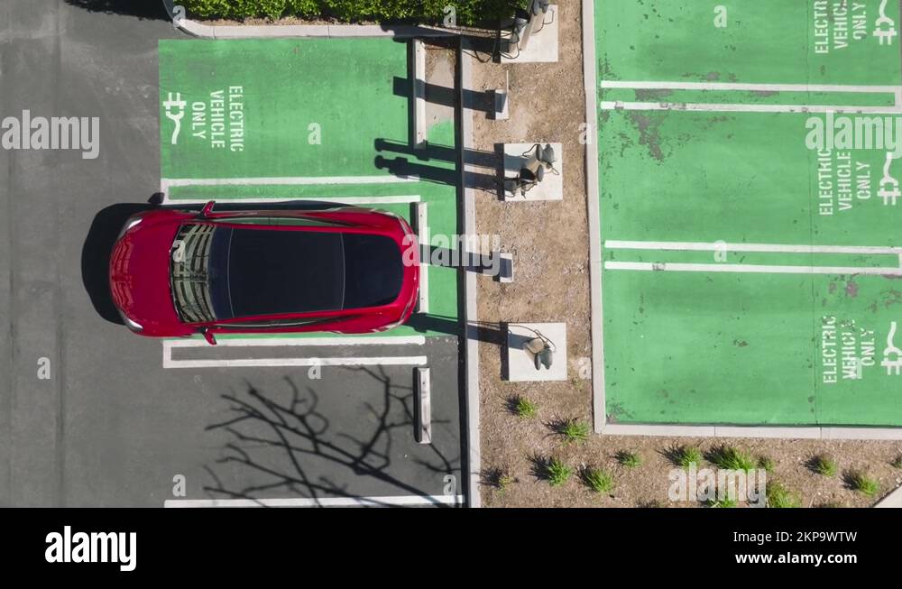 Drone raising up above modern red electric vehicle, Aerial electric car ...