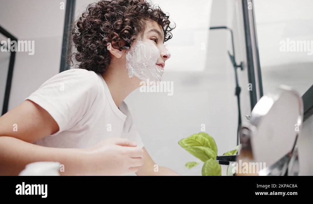 Cute boy with curly hair smears shaving cream on face Stock Video ...