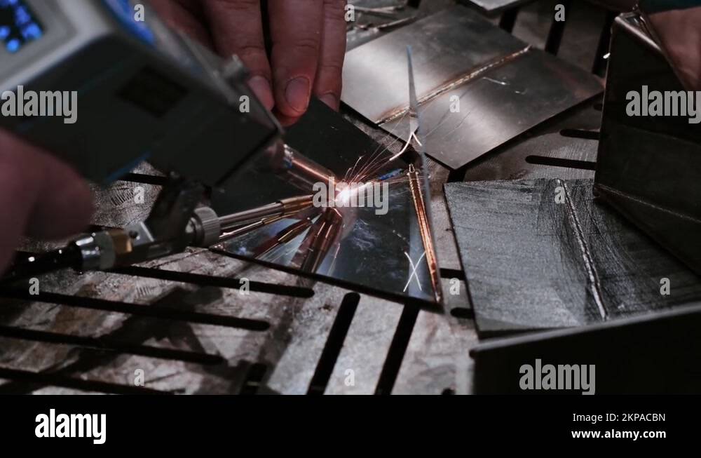 Welder hands using portable handheld laser welding machine with sparks ...