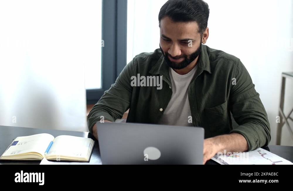 Positive smart indian or arabian man in casual clothes, freelancer or ...