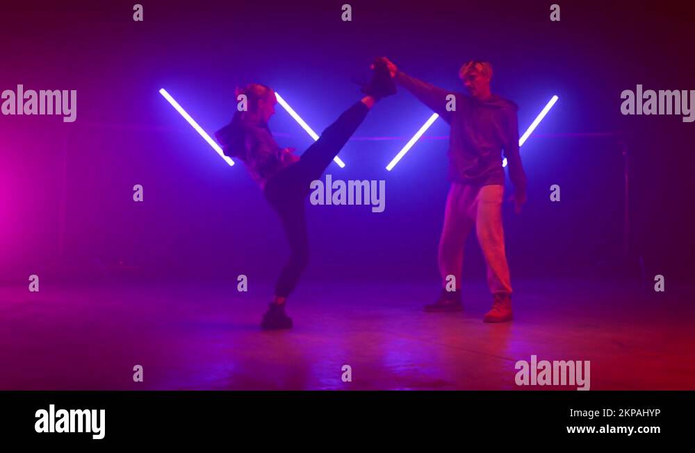 Trendy dancers battling playfully in freestyle dance. Couple dancing ...