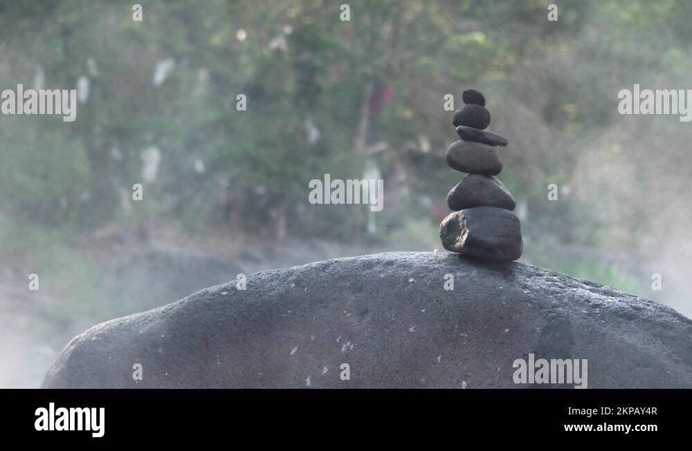 Balanced stones with steam emanating from the thermal hot springs of ...