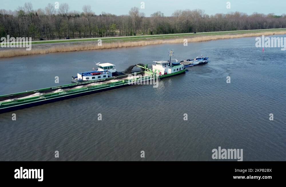 Dredging ship dredges off mud from river bottom to improve the fairway ...