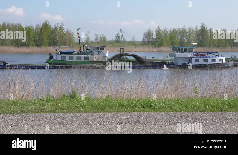 Dredging ship dredges off mud from river bottom to improve the fairway ...