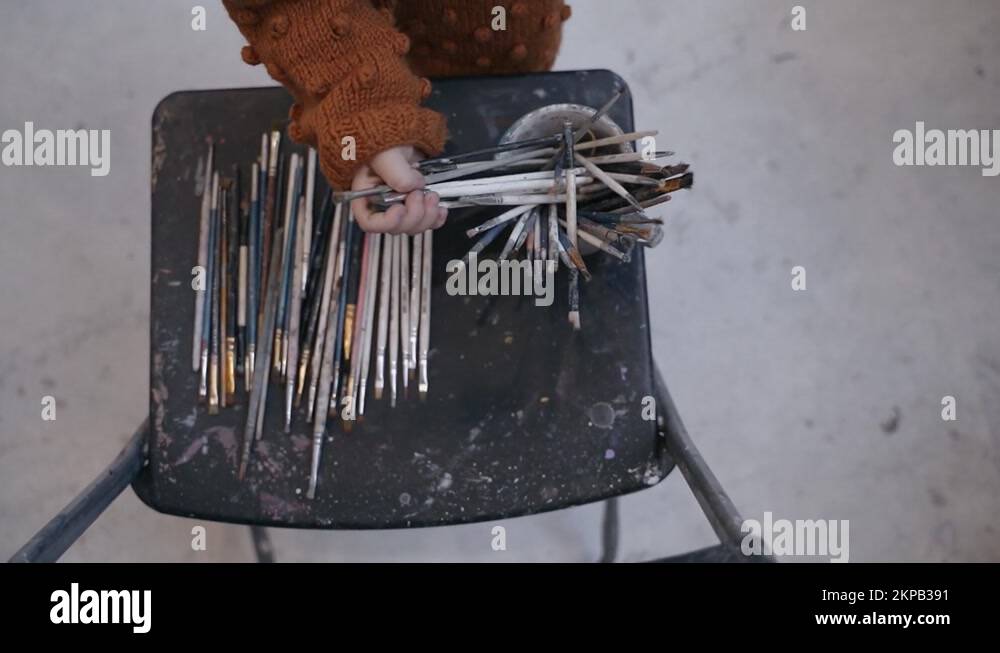 Top down view of artist grabbing a lot of used paint brushes Stock ...