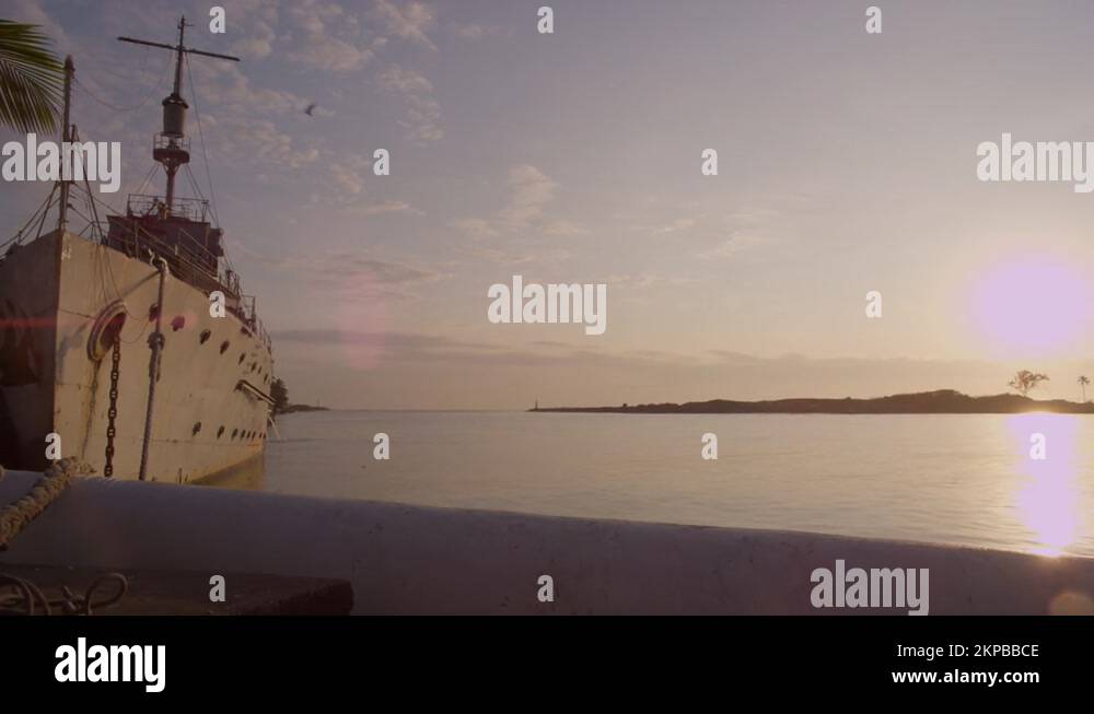 Navy ship docked with the sun rising and making beautiful flares in the ...