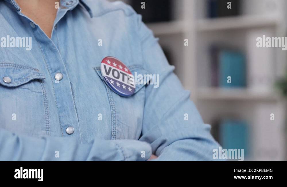 Female citizen wearing vote button, arms crossed on chest, freedom of ...