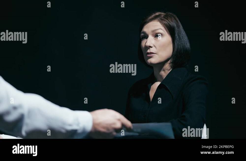 Detective showing crime scene picture to female suspect, questioning in ...