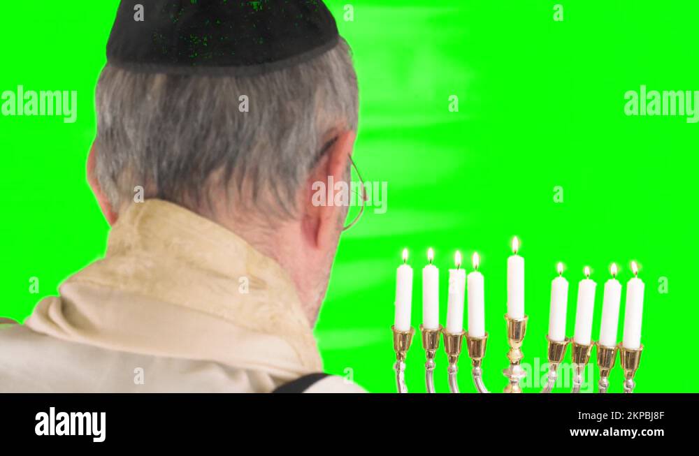 Jewish man praying in front of menorah candles on green screen chroma ...