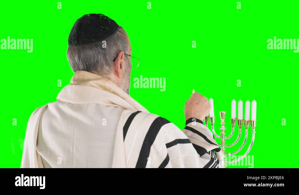 Jewish man lighting menorah candles on green screen isolated with ...