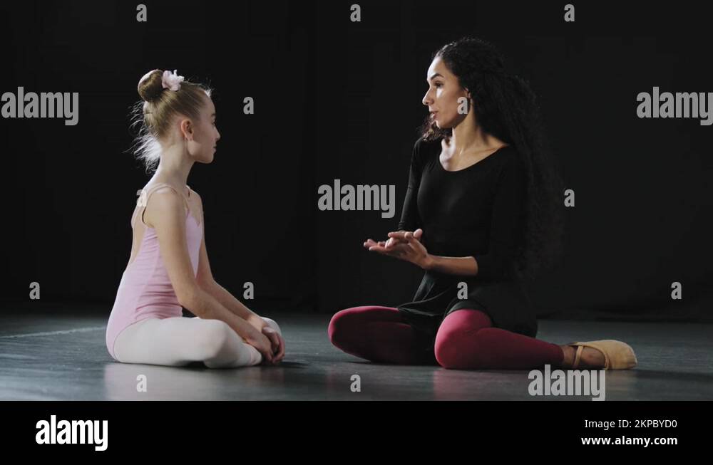 Little girl ballerina dancer beginner acrobat child in leotard sits on ...