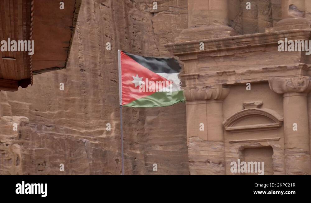 jordanian flag waving in the wind at ad deir monastery in the ancient ...