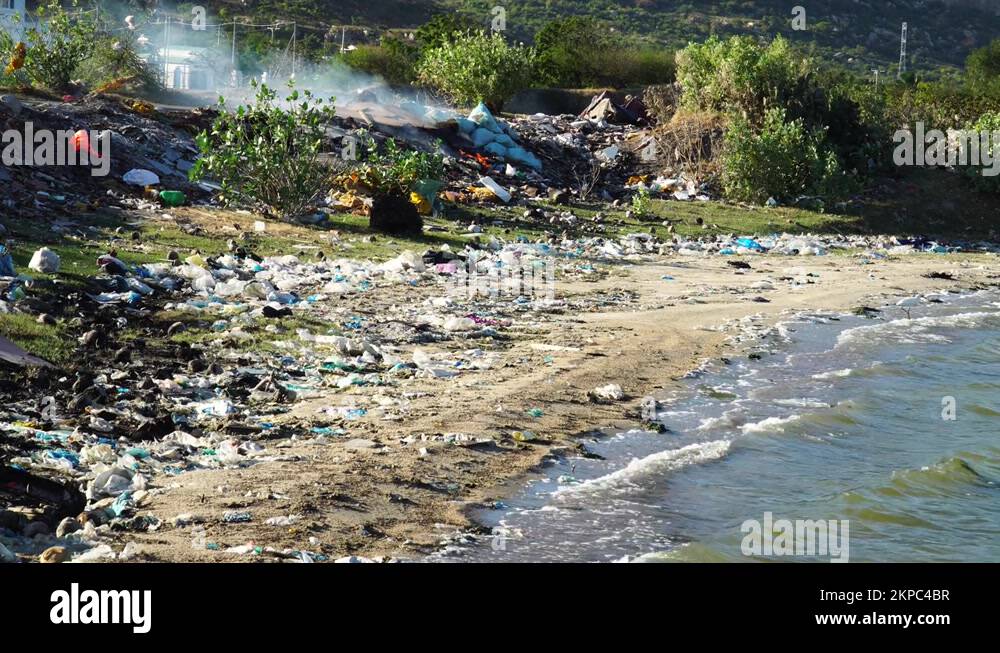 Dirty polluted beach shore full of ocean plastic trash. Rubbish burning ...