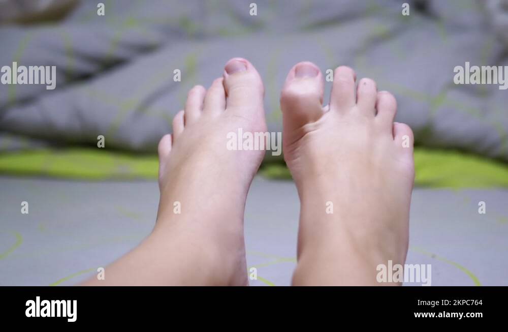 Close-up Tired Child Wiggles his Toes while Lying on the Bed in Room ...
