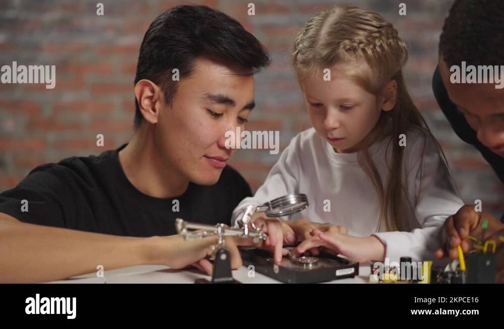 Asian engineer shows open hard disk drive to curious student Stock ...