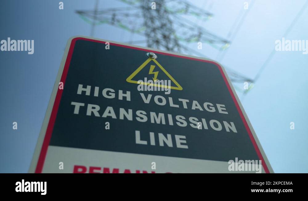 Close up of warning sign in front of hydroelectric tower, out of focus ...