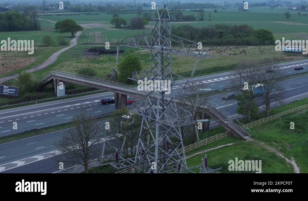 Speeding traffic passing pylon electricity tower on M62 motorway aerial ...