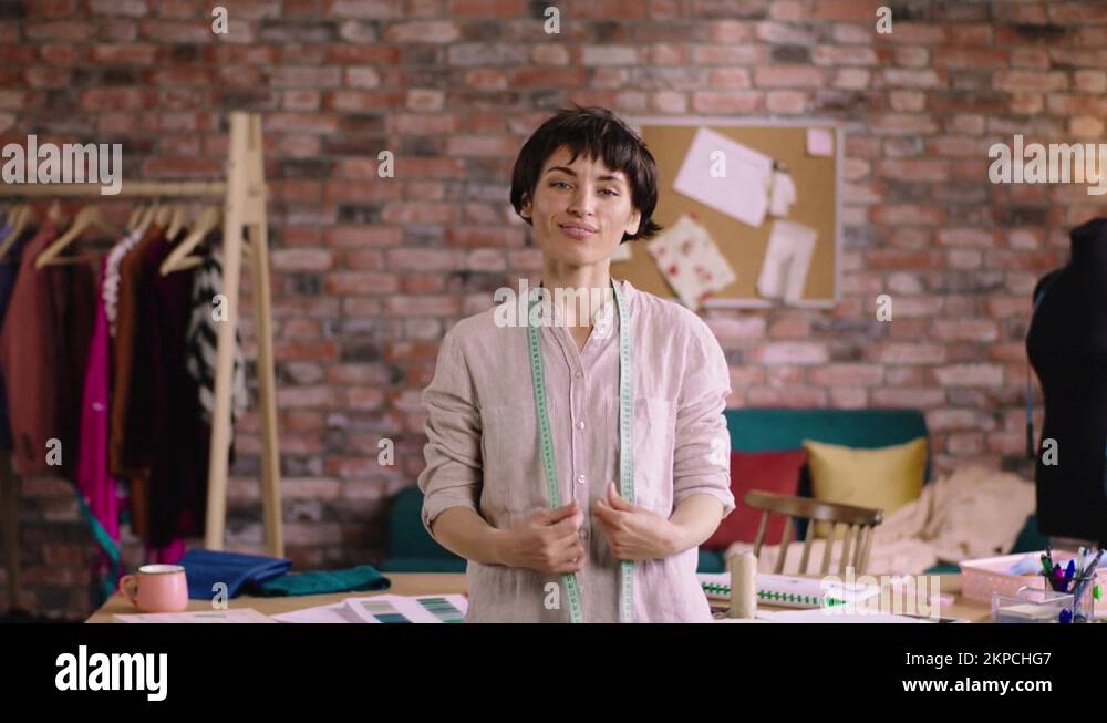 Pretty lady dressmaker posing happy in front of the camera at her ...