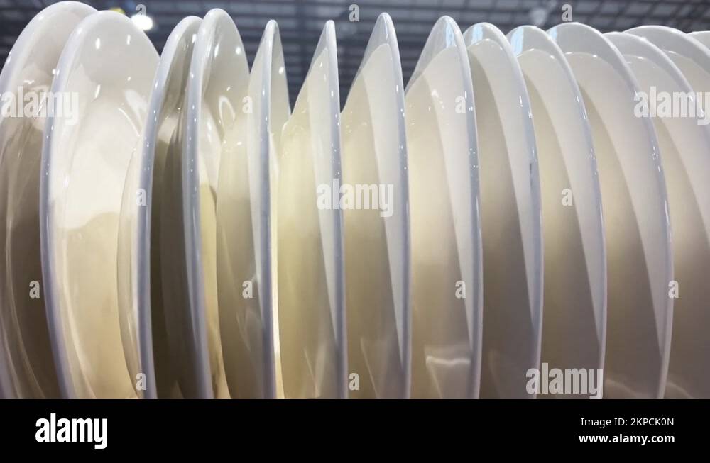 A row of clean plates stands vertically in the restaurant's kitchen ...