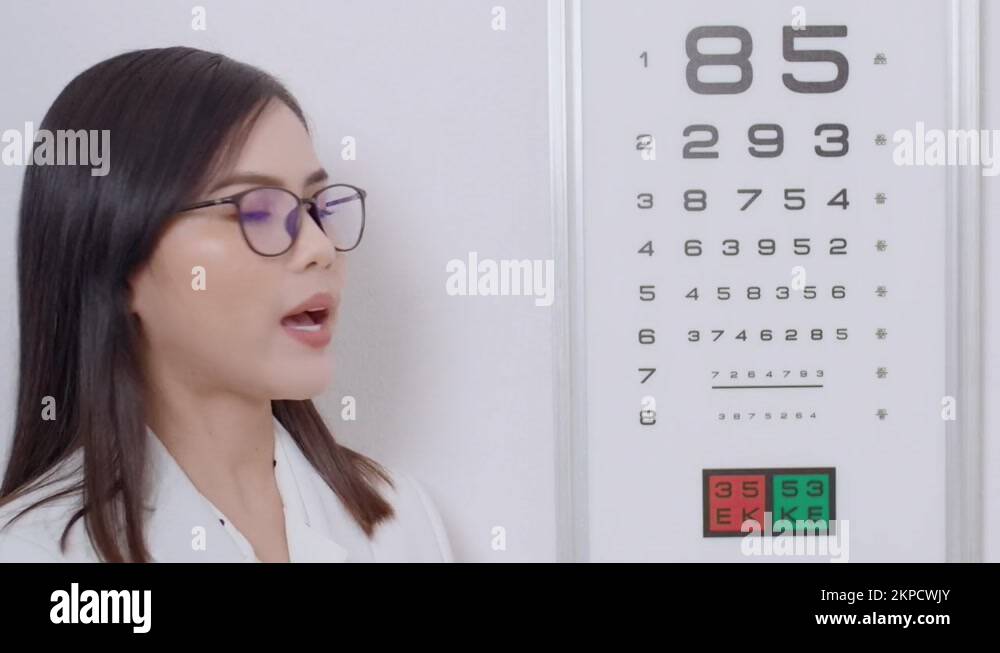 Young ophthalmologist doing visual test for customer using eye chart in ...