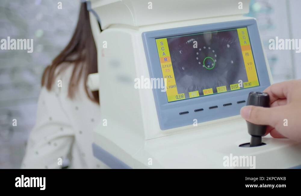 Young female customer being examined visual test using autorefractor by ...