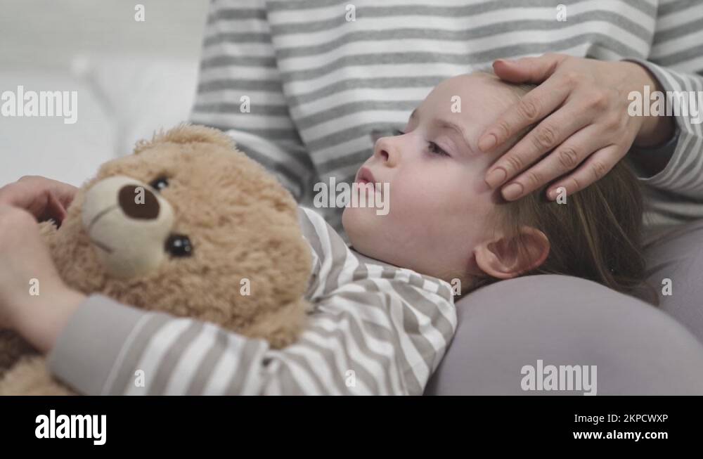 little child kid falls asleep mom lap hugging teddy bear. happy girl ...