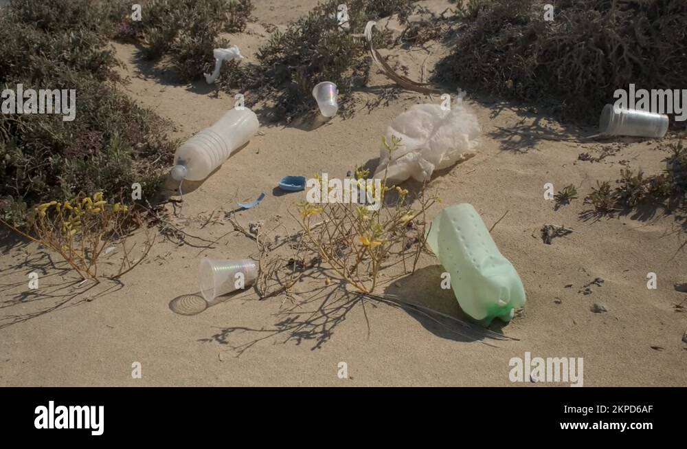 Plastic trash in the desert. Plastic pollution in a sandy desert in ...