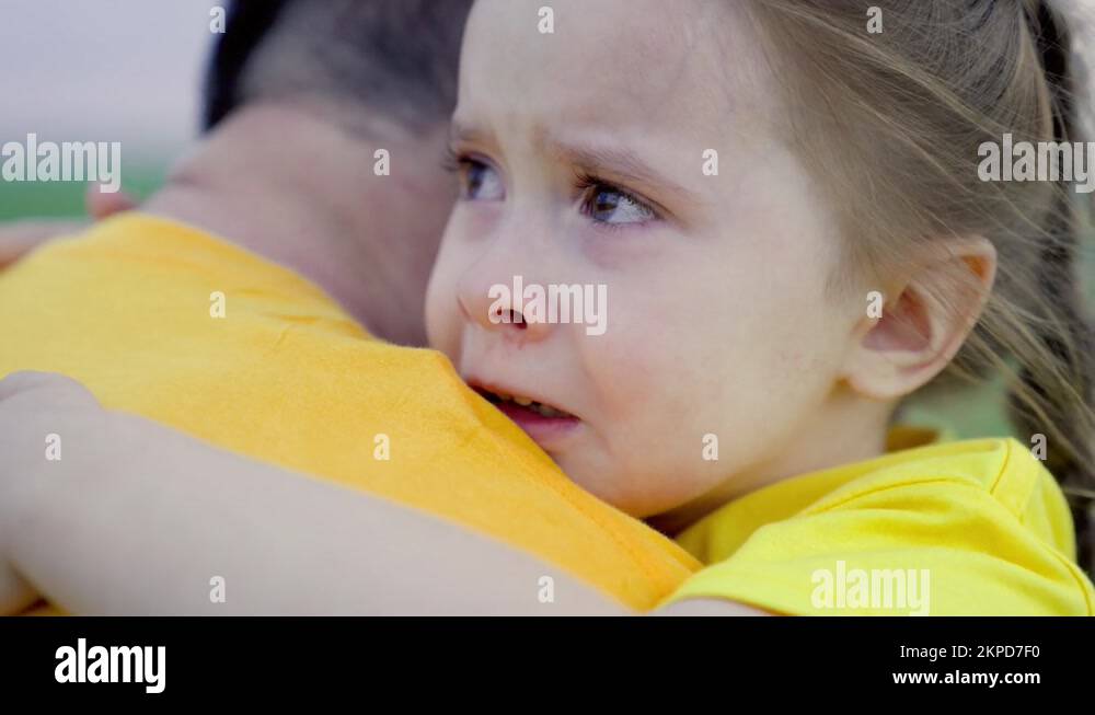 Dad hugs, reassures his little daughter. Baby daughter crying in park ...
