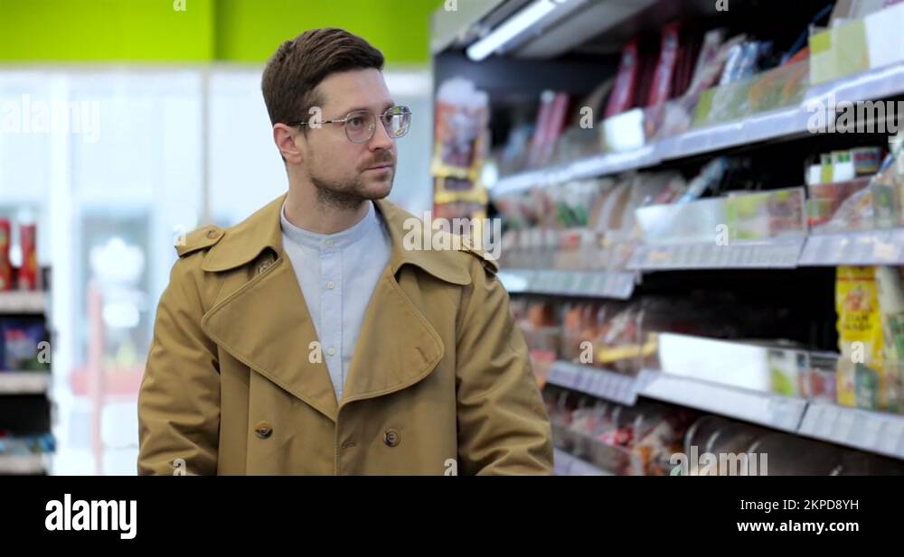 Man chooses products in the grocery store, put it to the cart. Dairy ...