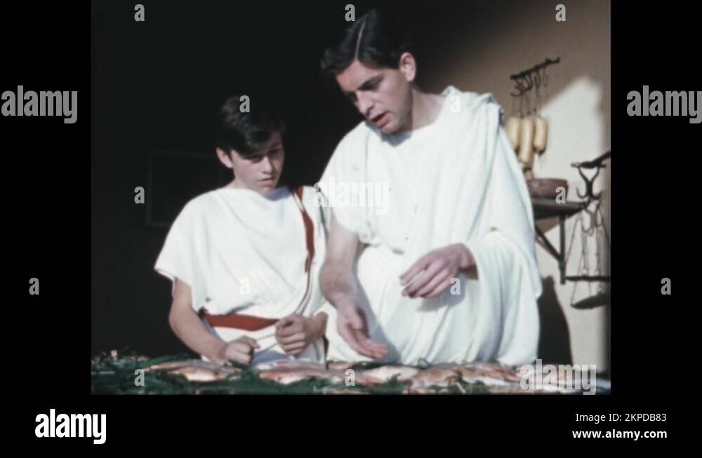 100 BC: Market, man, boy stand behind counter, man gestures, picks up ...