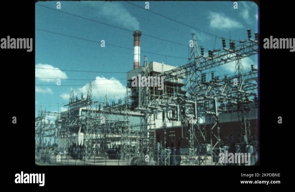 1980s: electrical power station with pylons and cables behind safety ...