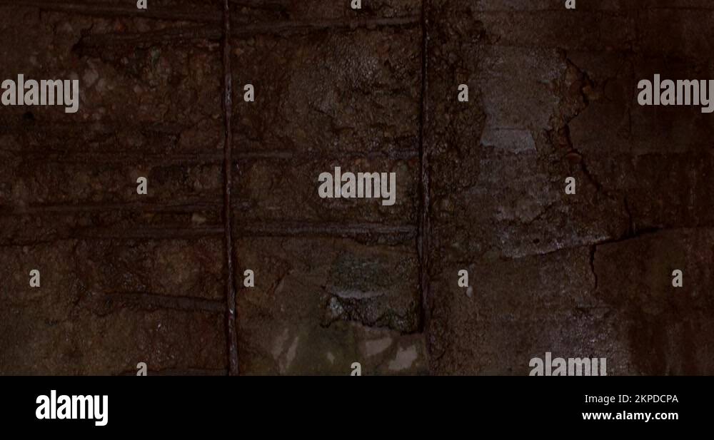 Rotten concrete wall in mold and moisture. Fittings sticking out, rust ...