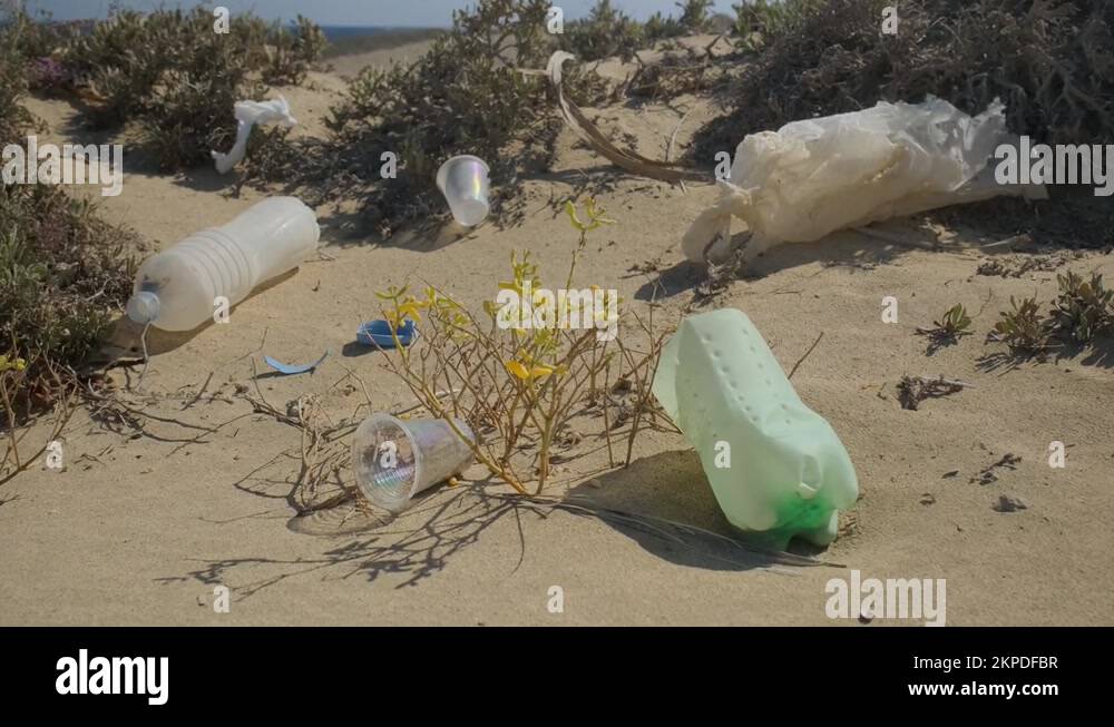 Plastic trash in the desert. Plastic pollution in a sandy desert in ...