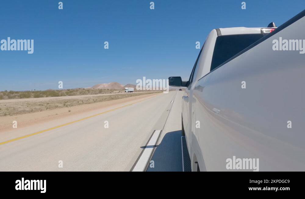 Driving along a highway through the hot and arid Mojave Desert ...
