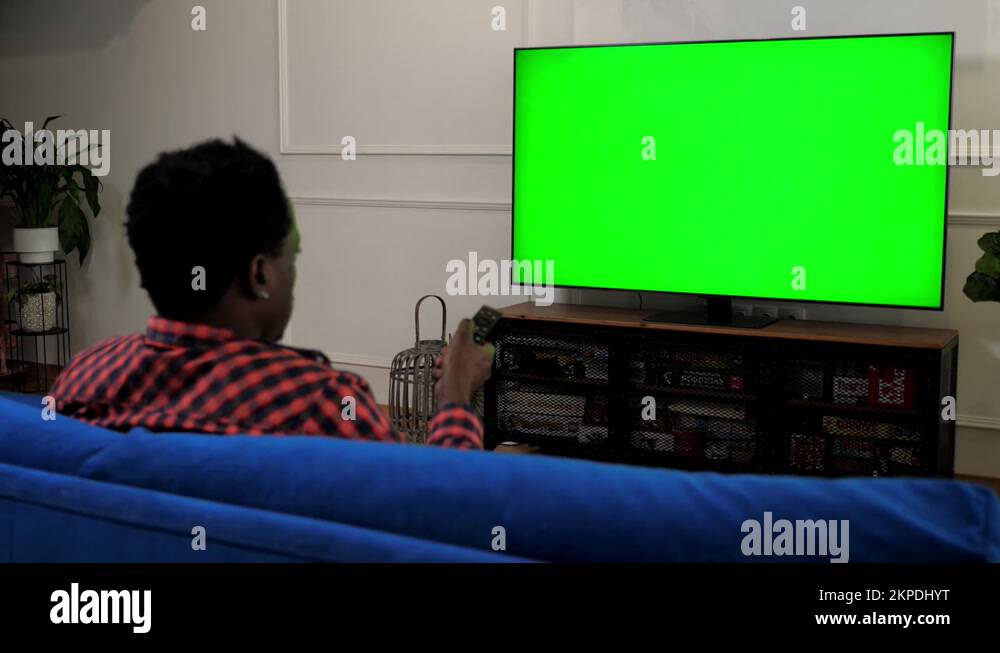 Green screen TV African American man looking at TV chroma key mock up ...