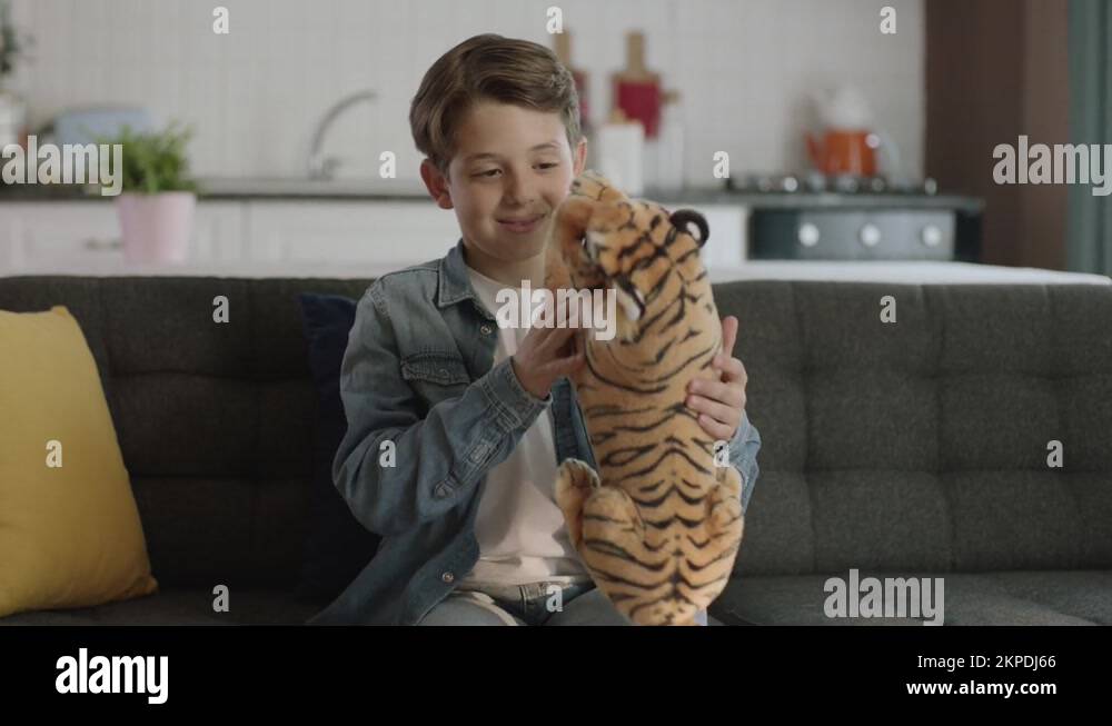 Home alone, little boy without friends plays with a toy tiger Stock ...