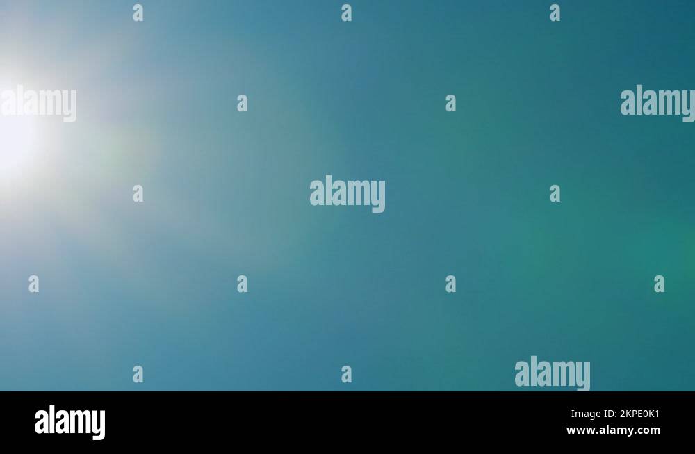 Sun with rays and glare, blue clear sky. Dynamic light rays, lens flare ...