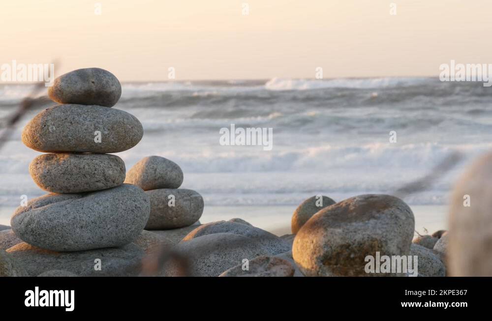 Rock balancing on pebble beach. Pyramid stacks of stones, ocean coast ...