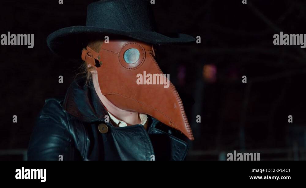 Criminal woman in plague doctor mask points gun at victim Stock Video ...