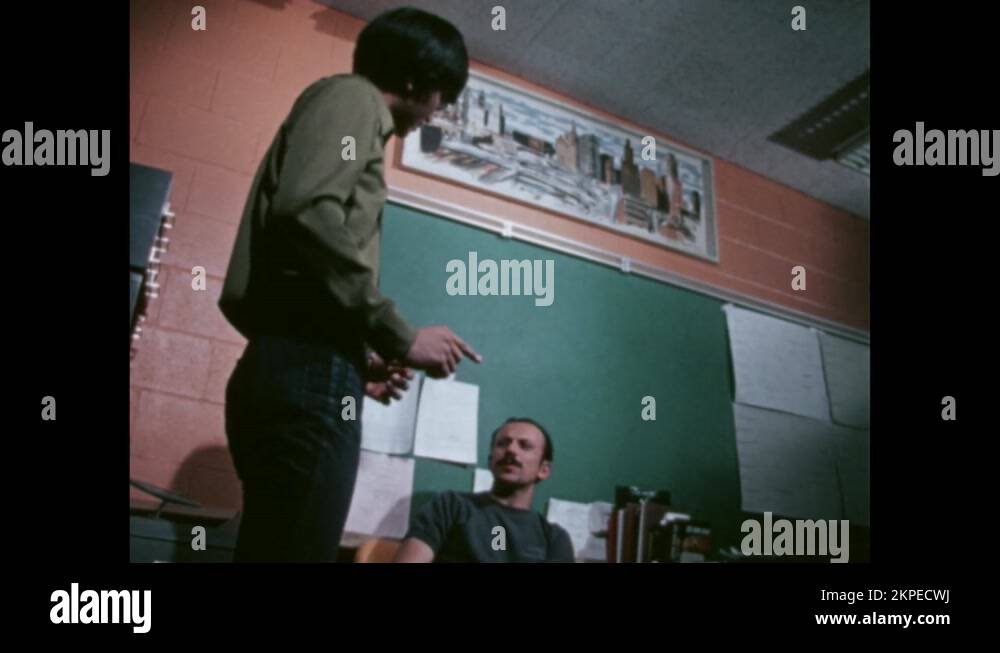 1970s: boy gives presentation at college. Hands type on Royal Futura ...