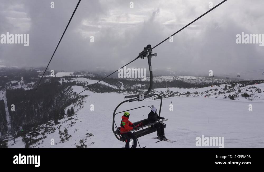 POV sliding down cable car, people going up, breathtaking winter white ...