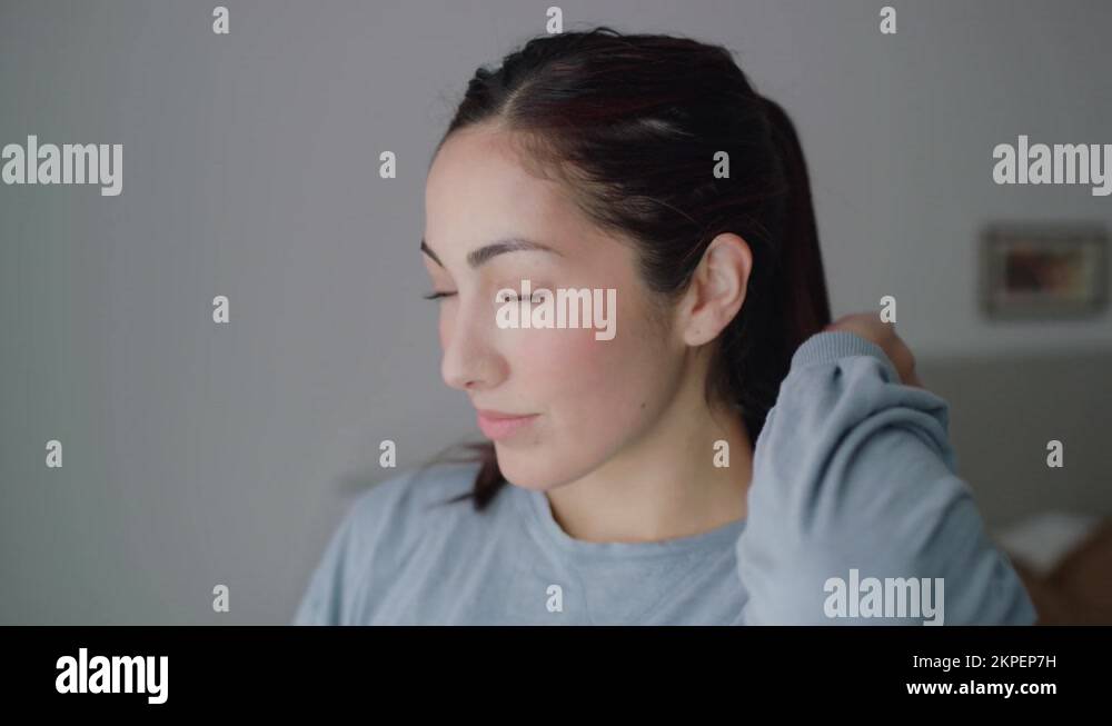 Beautiful brunette woman pulls hair back deep in thought with knowing ...