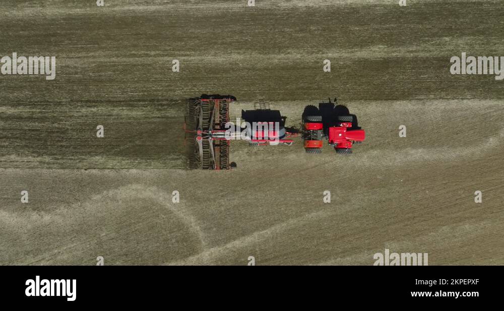 Tractor sowing seeds with seeder driller in field. Process of sowing ...