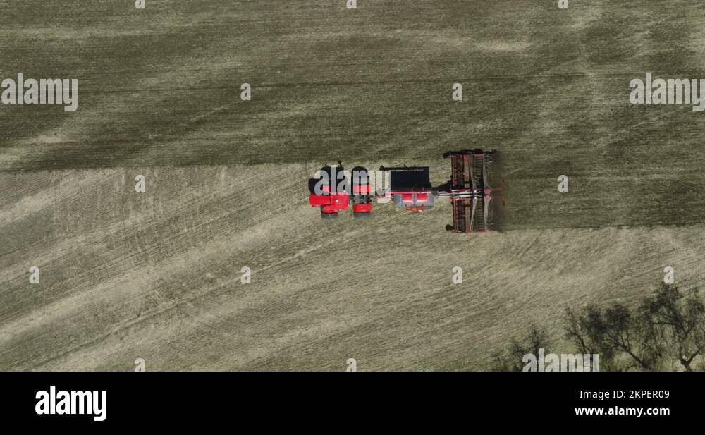 Tractor sowing seeds with seeder driller in field. Process of sowing ...