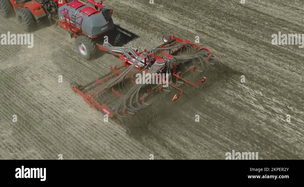 Tractor sowing seeds with seeder driller in field. Process of sowing ...